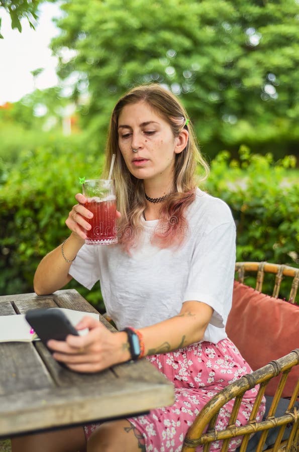 Cute Woman Scrolling a Phone and Drinking Tea in Summer Garden Stock ...