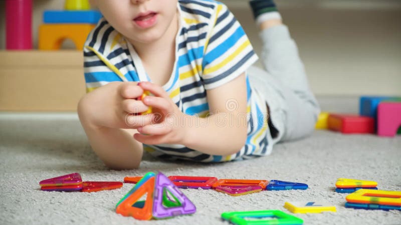 A Cute 5 Year Old Boy Creates Figures with a Magnetic Construction Kit ...