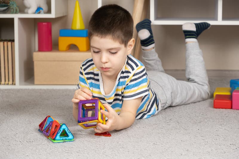 A Cute 5 Year Old Boy Creates Figures with a Magnetic Construction Kit ...