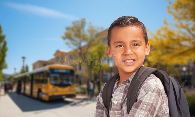 Cute Young Hispanic Boy Wearing a Backpack Near a School Bus on Campus ...