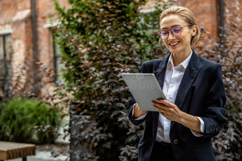 Cute Young Manager in Jacket and Pants with a Tablet Looking Busy Stock ...