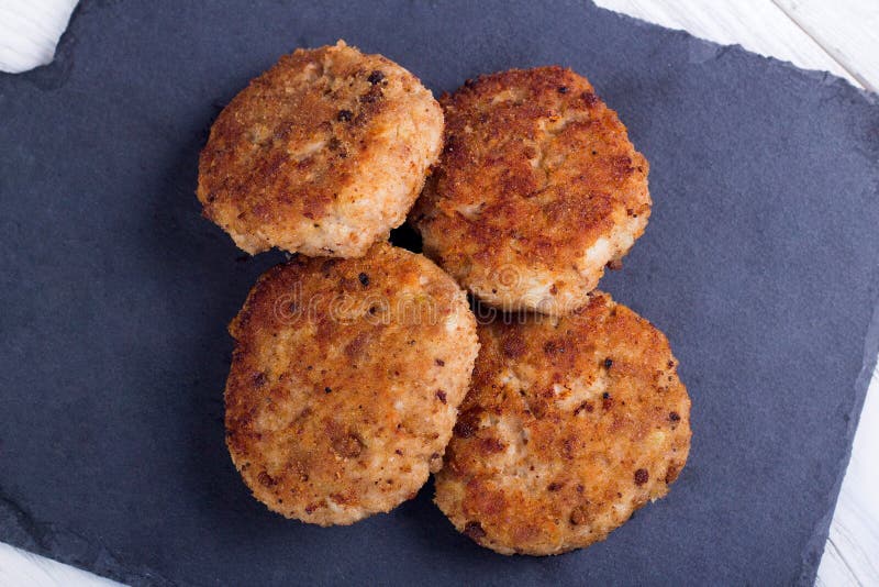 Cutlets on a Black Flat Plate, on a White Wooden Background Stock Photo ...