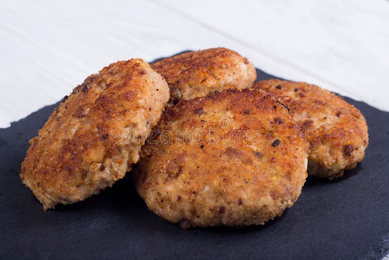 Cutlets on a Black Flat Plate, on a White Wooden Background Stock Image ...