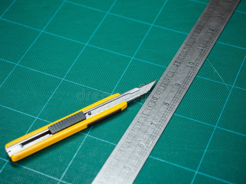 Cutter and Iron Ruler Isolated on a Cutting Mat Stock Photo - Image of ...