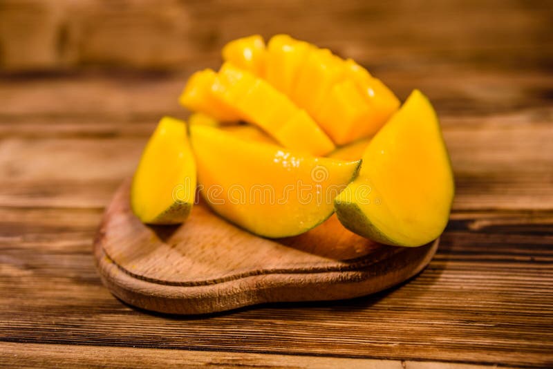 Cutting Board with Chopped Mango Fruit on a Wooden Table Stock Photo ...