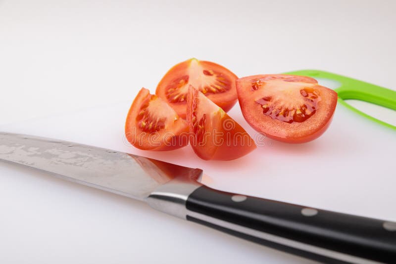 On a Cutting Board is a Fresh Red Cut Tomato and a Large Chef S Knife ...