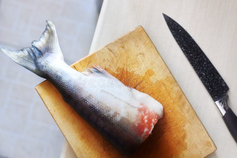 On the Cutting Board is a Piece of Fish and a Knife. the Cooking ...