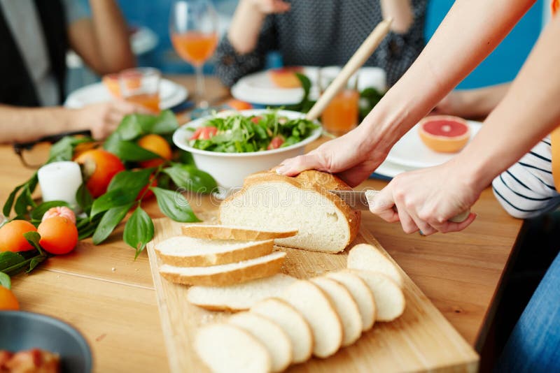 Cutting Bread at Dining Table Stock Image - Image of dinner, home ...