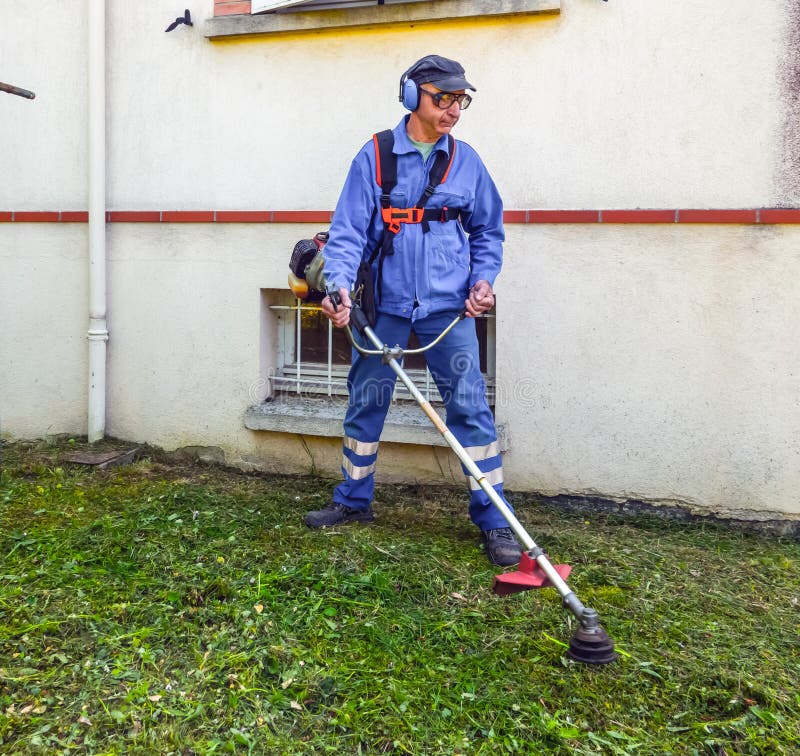 Cutting Grass in Garden with the Trimmer Stock Photo - Image of farmer ...