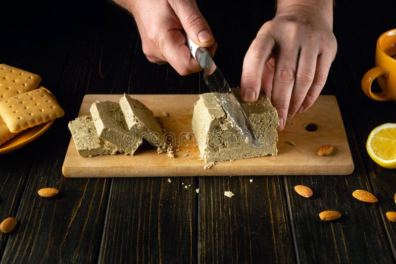 Cutting Halva with a Knife in the Hands of a Chef on a Cutting Board in ...