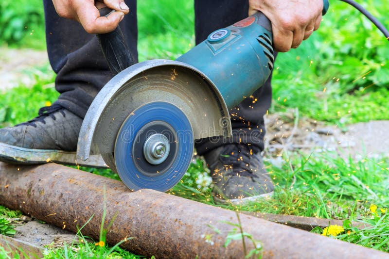 When Cutting Metal Frame, Worker Uses an Angle Grinder Hand Saw for a ...