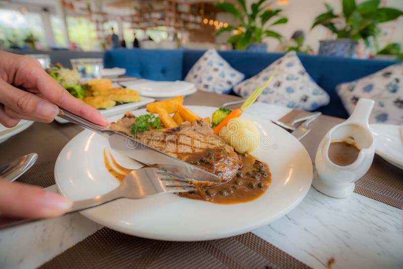 Cutting the Steak by Knife in White Dish while Take a Dinner Stock ...
