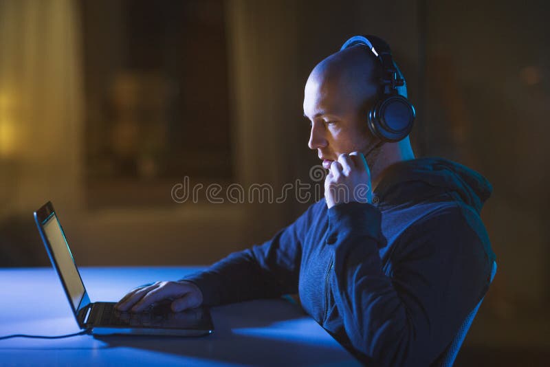 Hacker in Earphones Typing on Laptop in Dark Room Stock Image - Image ...
