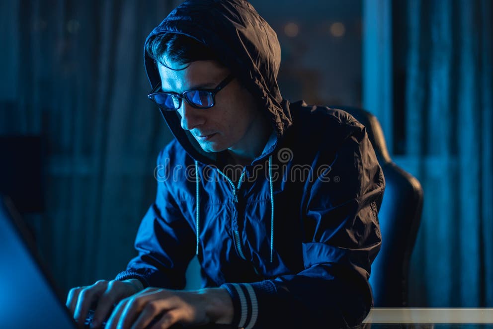 Cybercriminal Hacker in the Hood Typing Program Code while Stealing Access Databases with ...