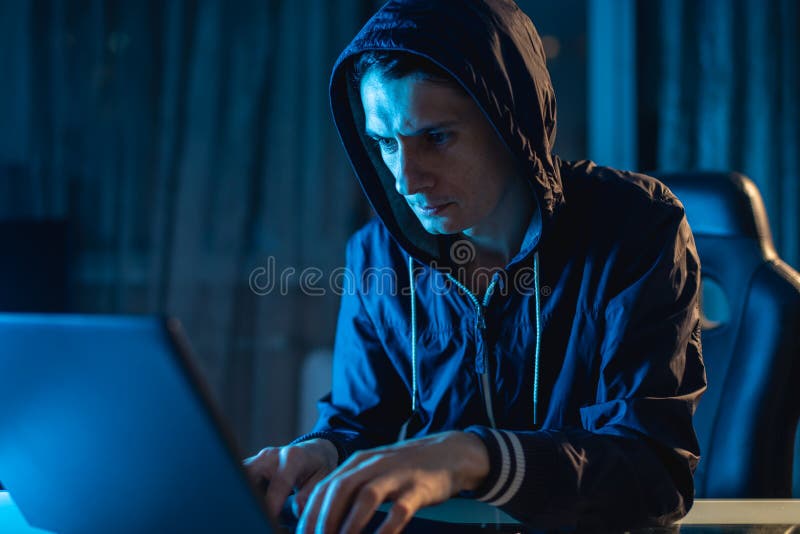 Cybercriminal Hacker In The Hood Typing Program Code While Stealing Access Databases With