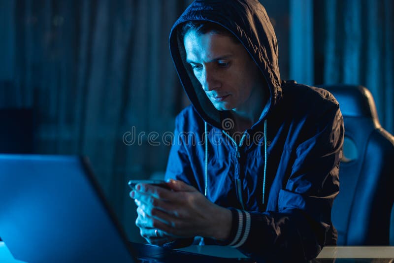 Cybercriminal Hacker In The Hood Typing Program Code While Stealing Access Databases With