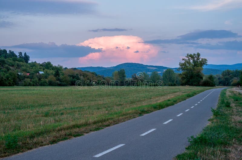Cycle Path at Dusk with Pink Cloud in the Blue Sky Stock Photo - Image ...