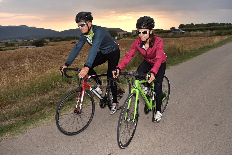 Cycling couple on a road stock image. Image of healthy - 125677173