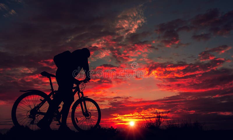 Cyclist with a Bicycle, in the Background Fiery Sunset Stock Photo ...