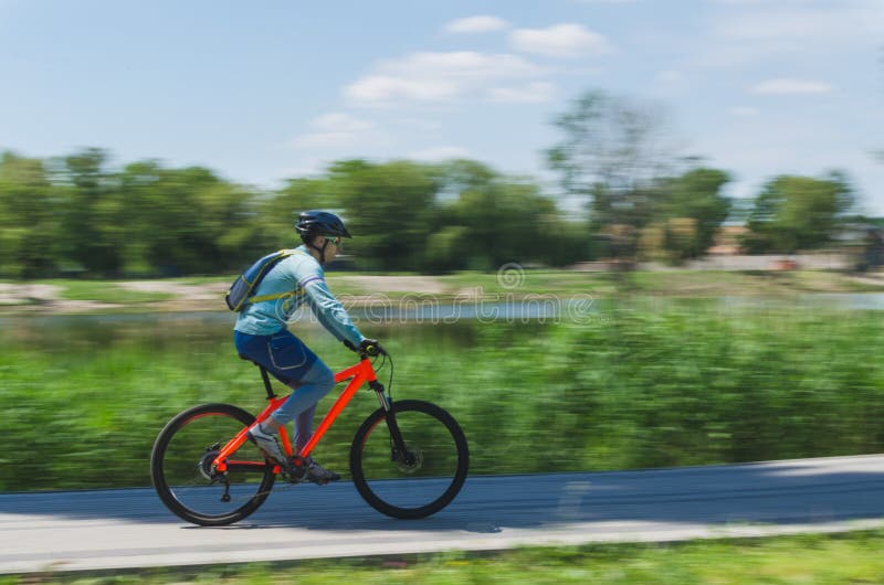 A Cyclist in a Helmet Rides a Bicycle Path, Motion Blur Stock Photo ...