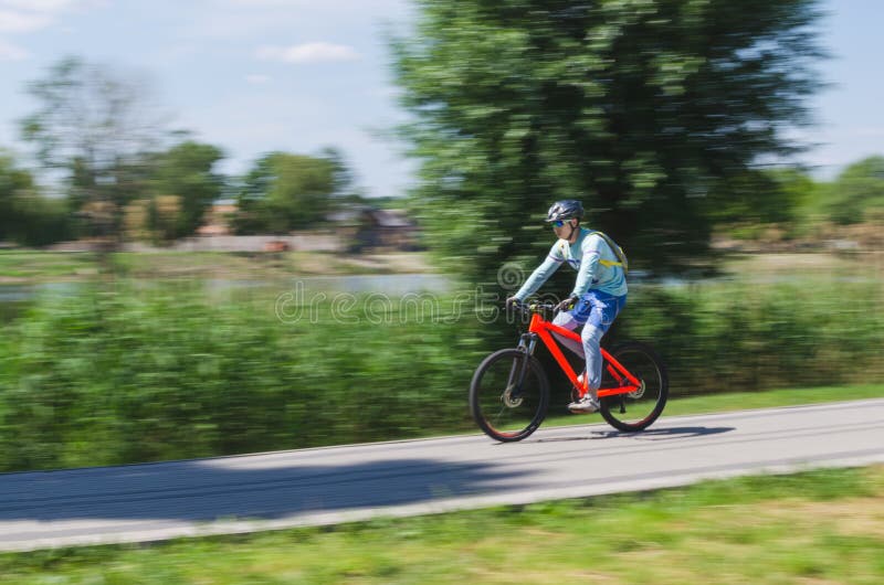 A Cyclist in a Helmet Rides a Bicycle Path, Motion Blur Stock Photo ...