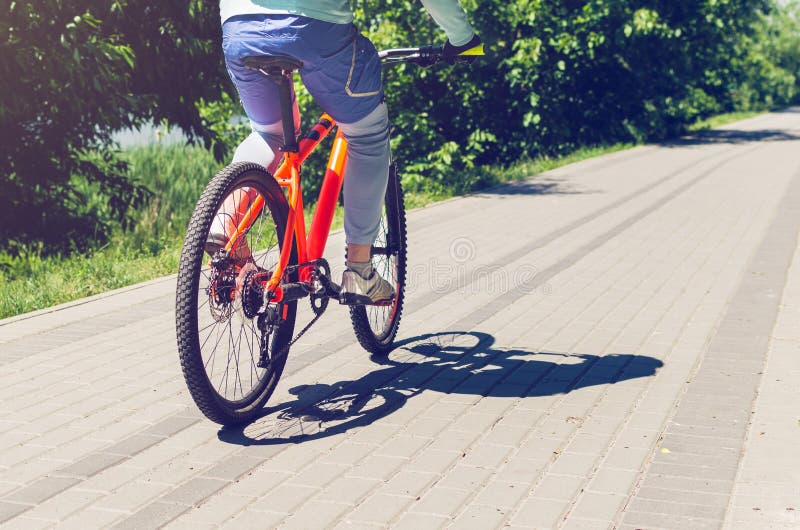Cyclist on an Orange Bike Riding a Bicycle Path Stock Photo - Image of ...