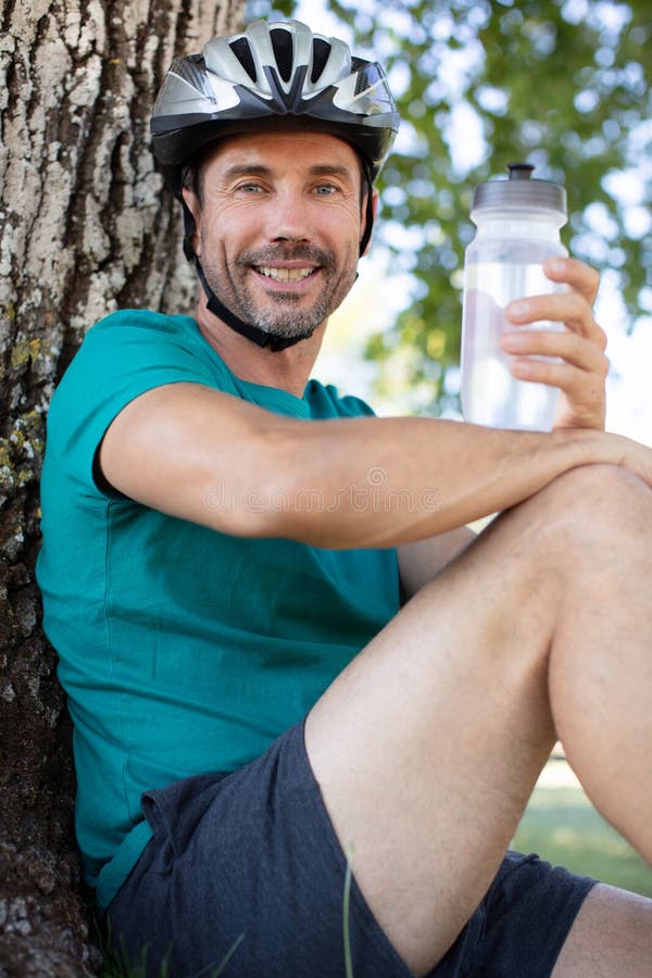 Cyclist Resting Under Tree after Exercising Drinking Water from Bottle ...