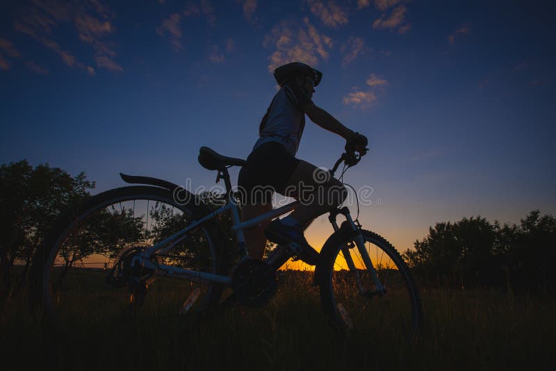 Cyclist Riding Bike at Sunset Stock Photo - Image of biker, people ...