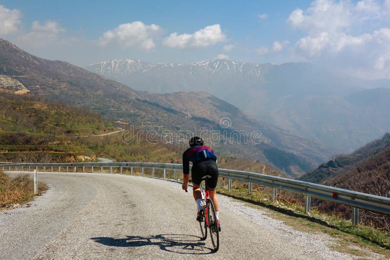 Cyclist on the Road. the View of the Road with Mountains in the ...