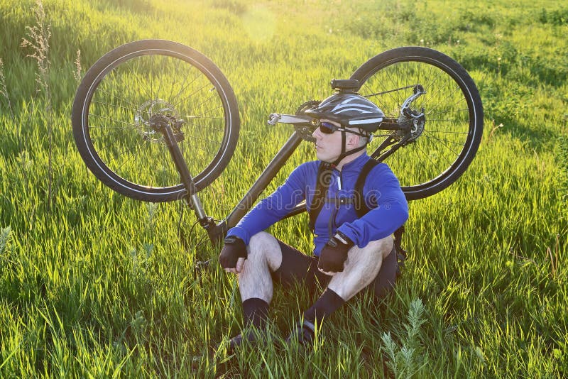 The Cyclist Sitting on the Grass Near the Bike Stock Image - Image of ...
