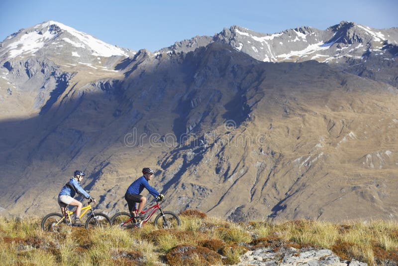 Cyclists Riding Past Mountains Stock Photo - Image of outdoors ...