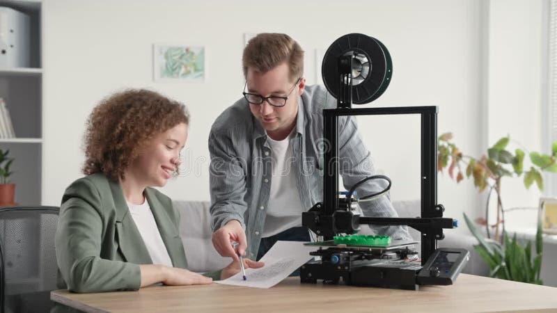 3 D Printing Models at Home, Smiling Girl with Young Guy are Watching ...