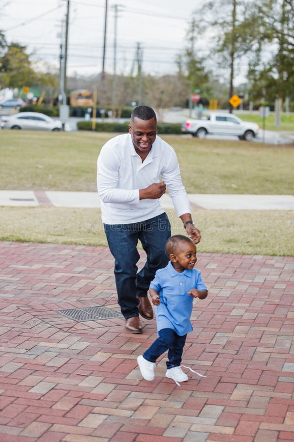 A Dad Chasing His Toddler Son Around Outdoors while they are Playing ...