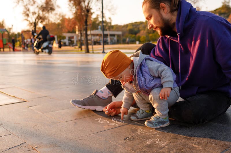 Dad and Child Draw with Chalk on the Pavement. Stock Photo - Image of ...