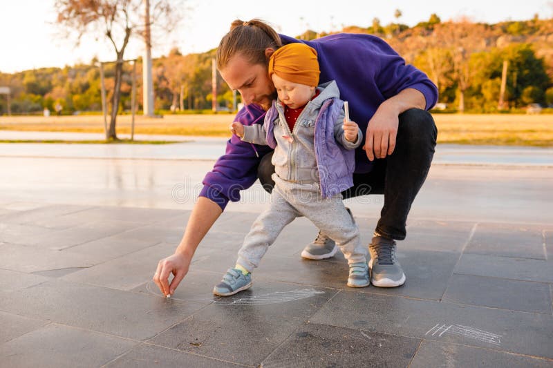 Dad and Child Draw with Chalk on the Pavement. Stock Image - Image of ...