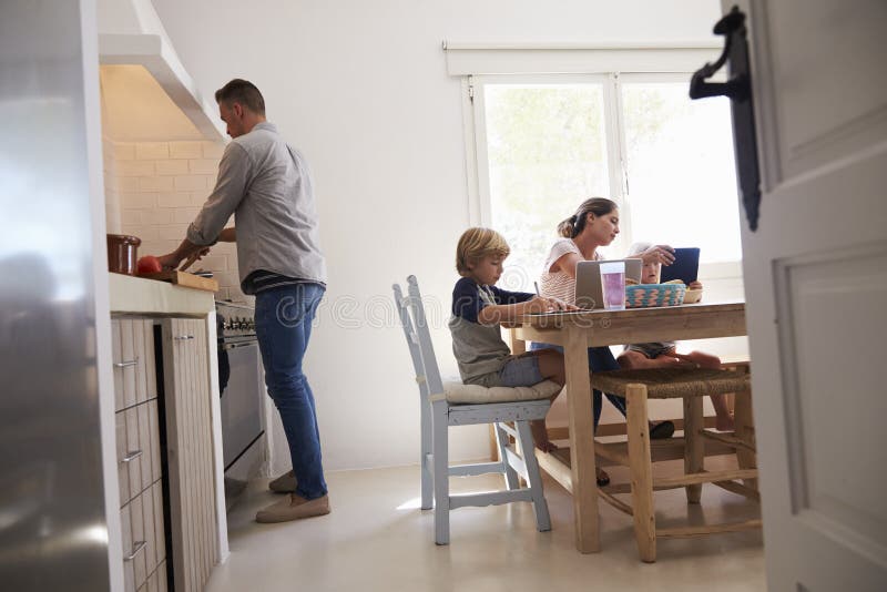 Dad Cooking and Mum with Kids at Kitchen Table, Low Angle Stock Image ...