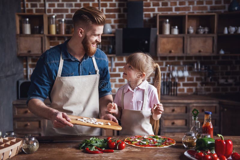 Dad and daughter cooking stock image. Image of cheese - 295607107