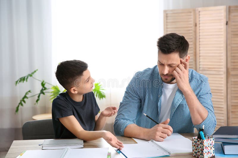 Dad Helping His Son with Homework Stock Photo - Image of child, indoors ...