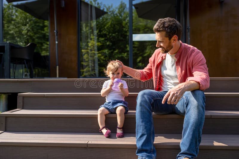 Dad and Little Son Sitting on the Steps and Looking Contented Stock ...