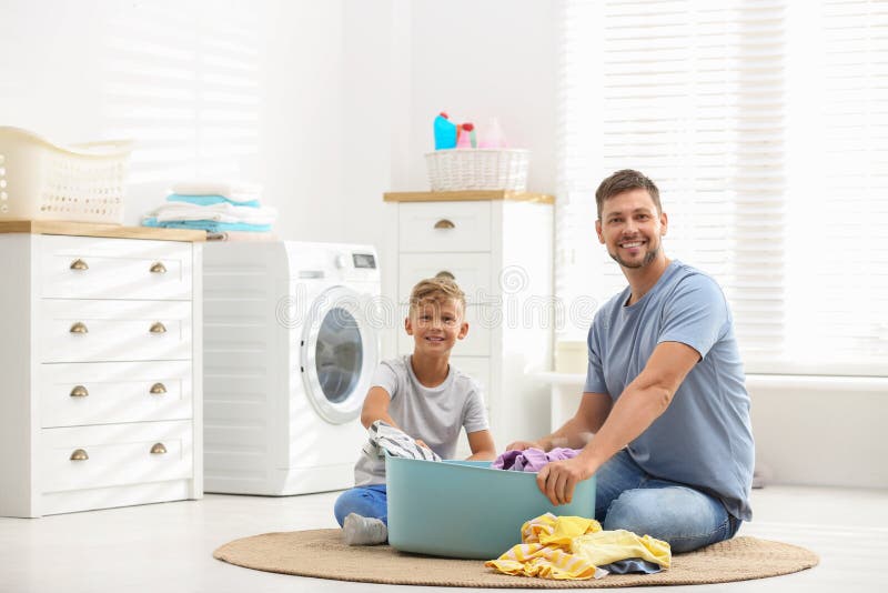 Dad and son doing laundry stock image. Image of machine - 161048827