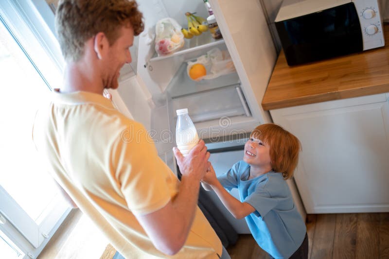Ginger Man with a Bottle of Milk in Hands Getting Ready the Breakfast ...