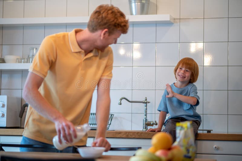 Ginger Man with a Bottle of Milk in Hands Getting Ready the Breakfast for His Son Stock Photo ...
