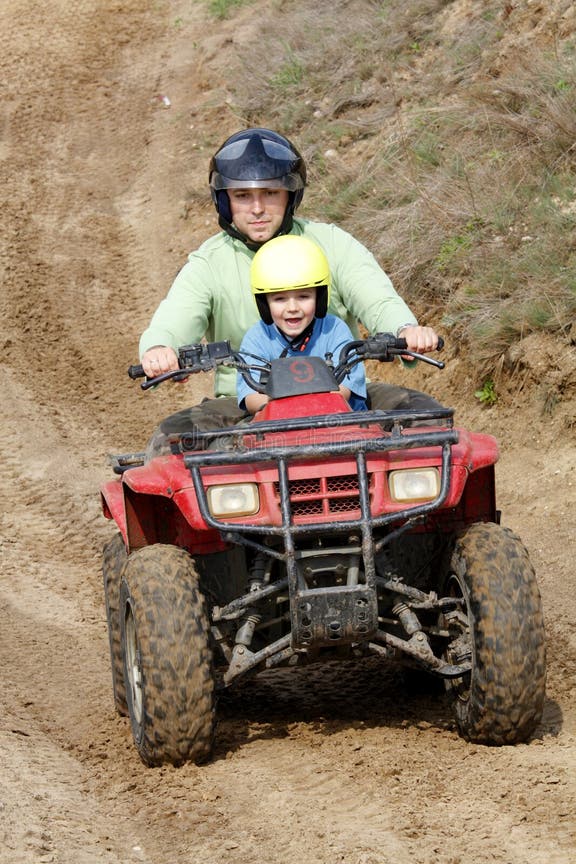 Dad with son riding a quad stock photo. Image of motion - 5294972