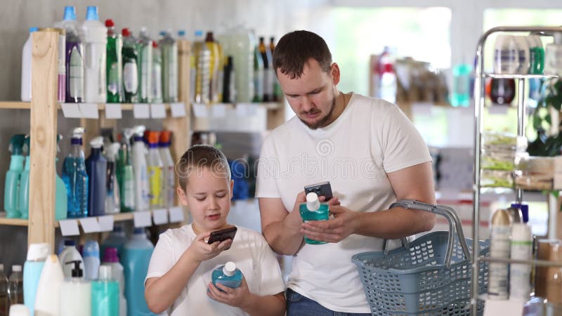 Dad and Son Scan Barcode on Packaging of Mouthwash Stock Footage ...