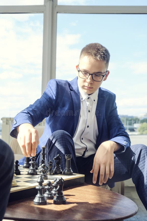 Dad and Son are Sitting at a Table by a Wide Window and Playing Chess ...