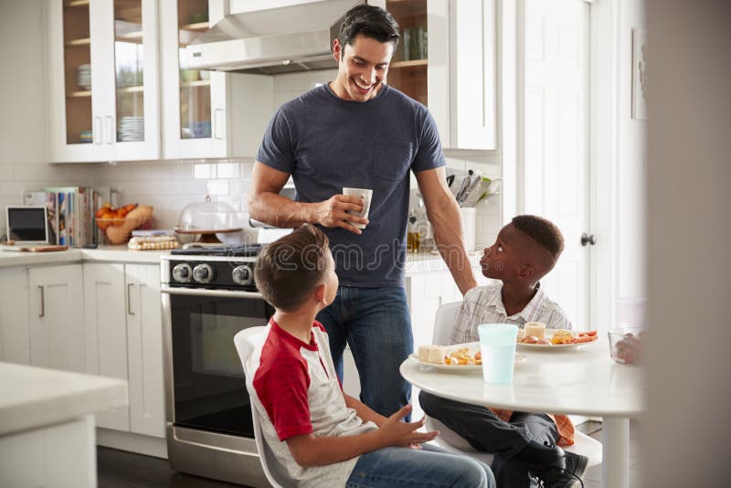 Dad Standing in the Kitchen Talking with His Son and a Friend, Who is ...