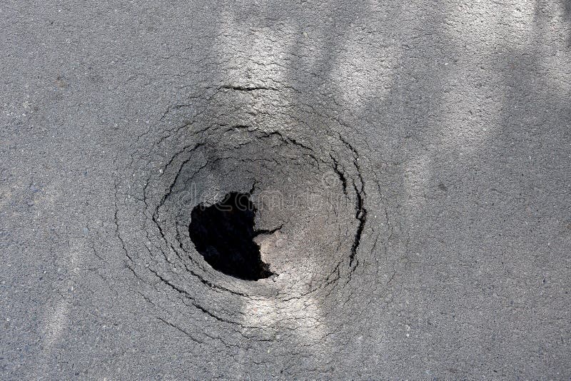 Damage in the Asphalt Pavement in the Form of a Crater. Stock Photo ... Damage in the Asphalt Pavement in the Form of a Crater. Stock Photo ...