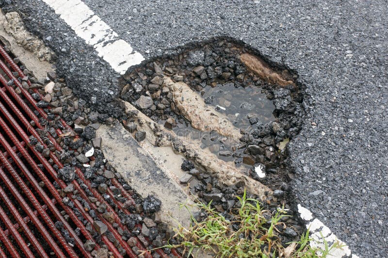 Damage on the asphalt road stock photo. Image of rock - 59773830