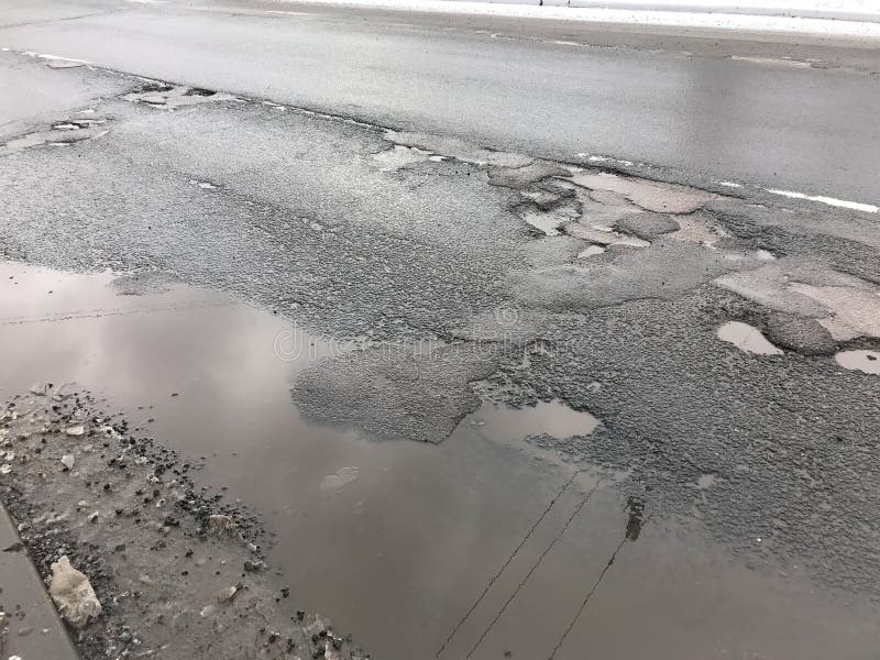 Damaged Asphalt Road with Potholes Inundated with Water Stock Photo ...