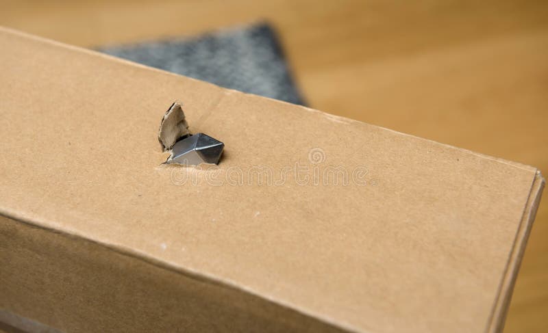 Damaged Parcel Cardboard with a Steel Sharp Object Inside Stock Photo ...